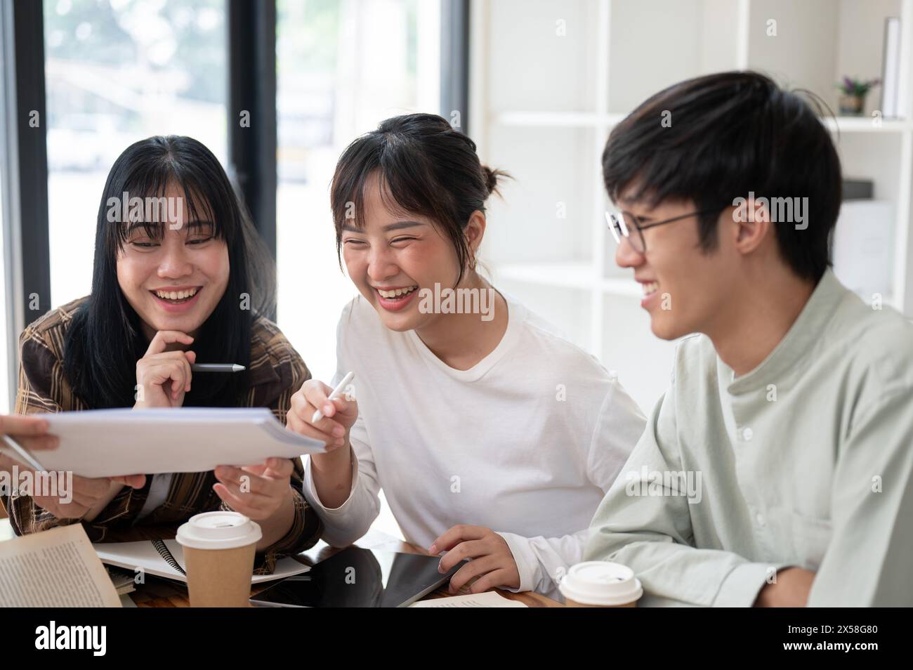 A group of cheerful Asian college students is enjoying studying math ...