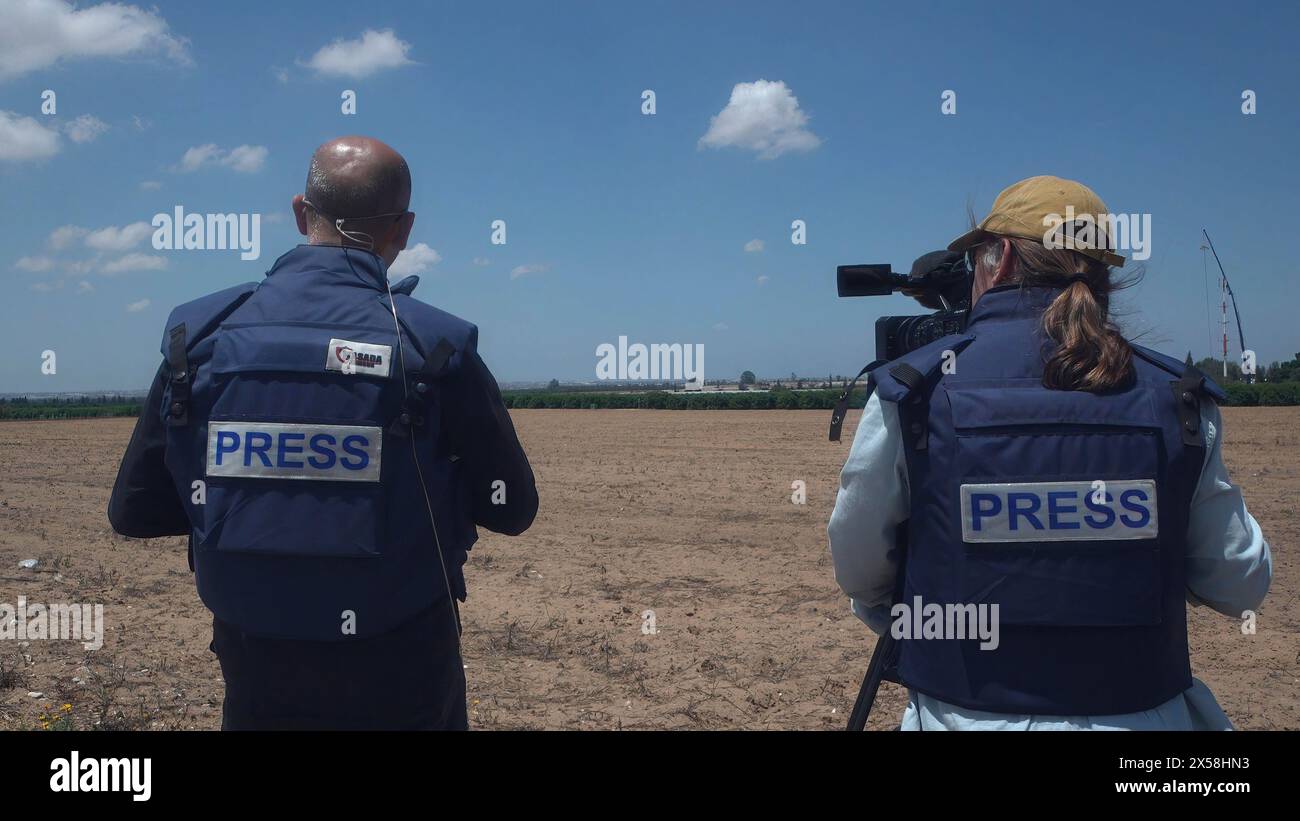 Journalists wearing protective flak jacket marked 'Press' report near ...