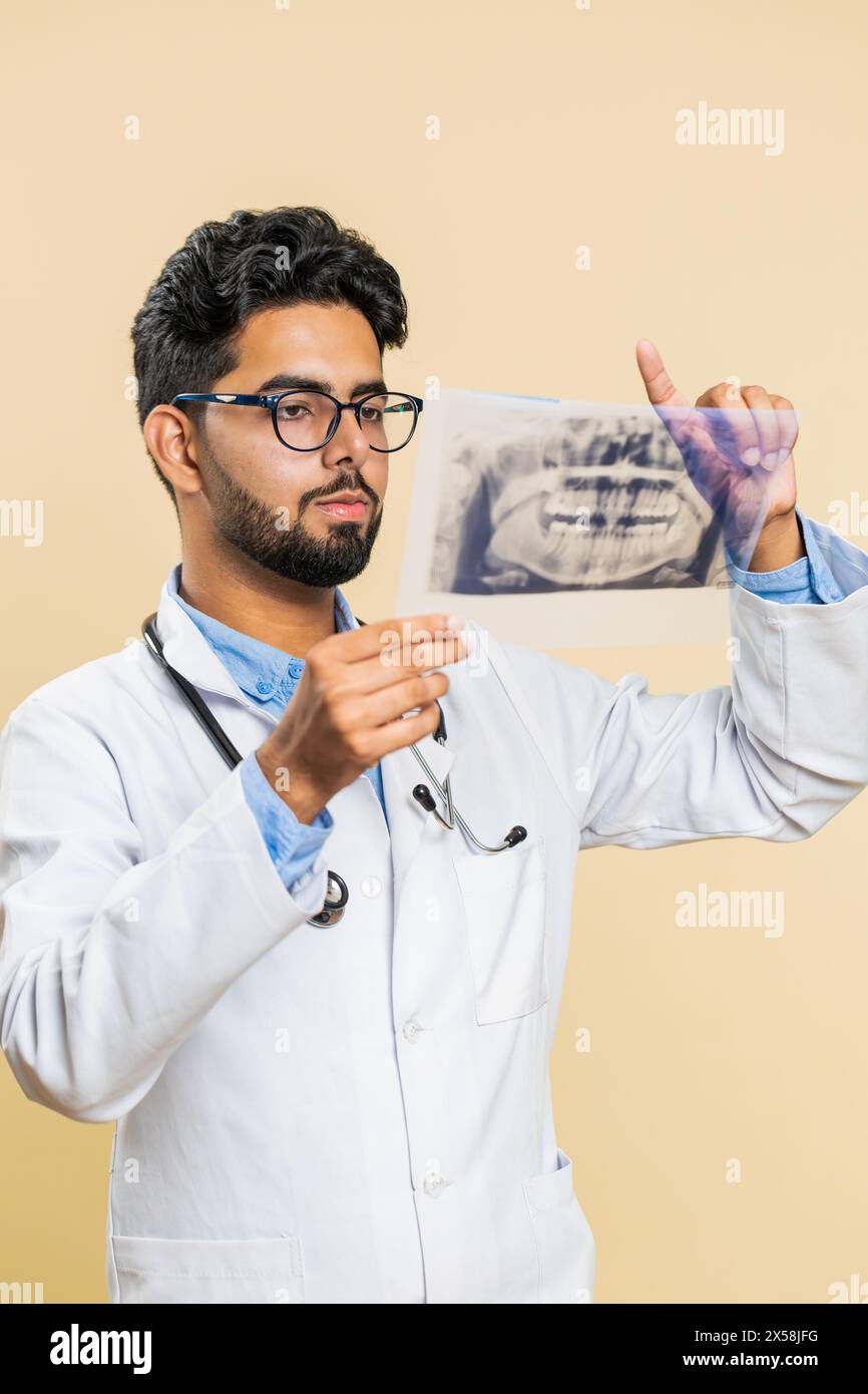 Indian young doctor orthodontist man examines a panoramic x-ray picture ...