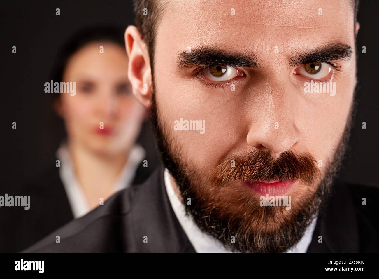 Commanding young businessman in a suit dominates the frame, his eyes ...