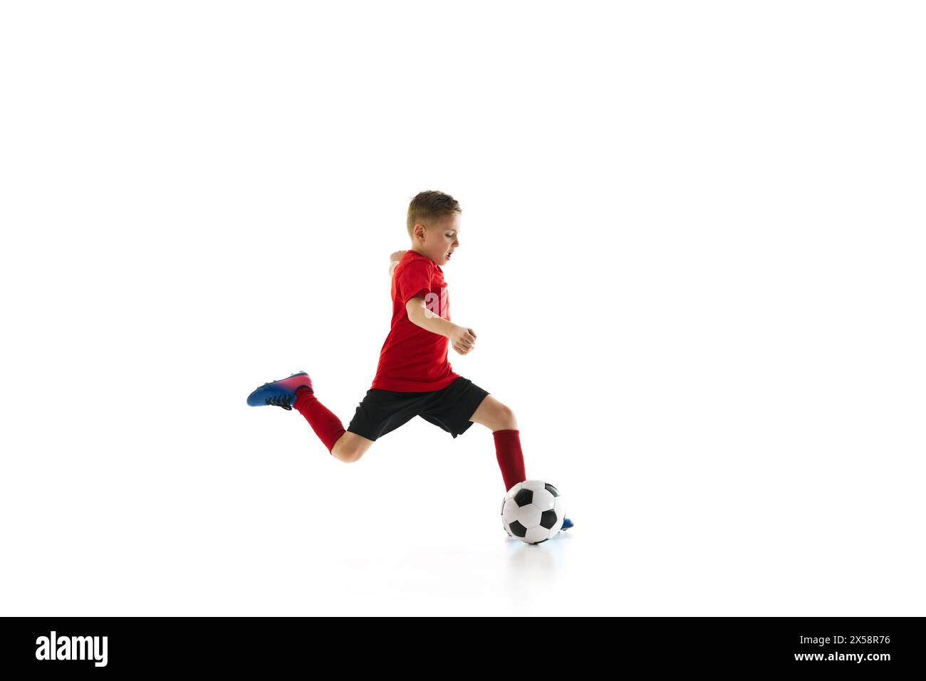 Boy kicking soccer ball in motion to take perfect pass against white ...