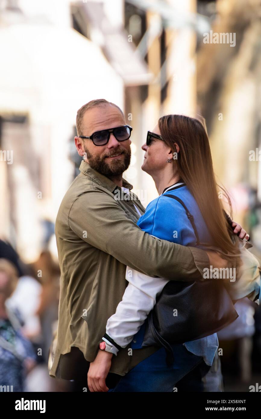 Street scene captures couple hugging among pedestrians, romantic moment ... Street scene captures couple hugging among pedestrians, romantic moment ...