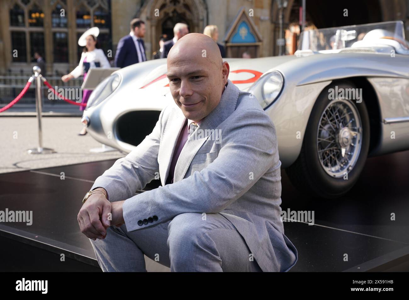 Elliot Moss poses in front of the Mercedes-Benz 300 SLR 722 on display outside Westminster Abbey ...