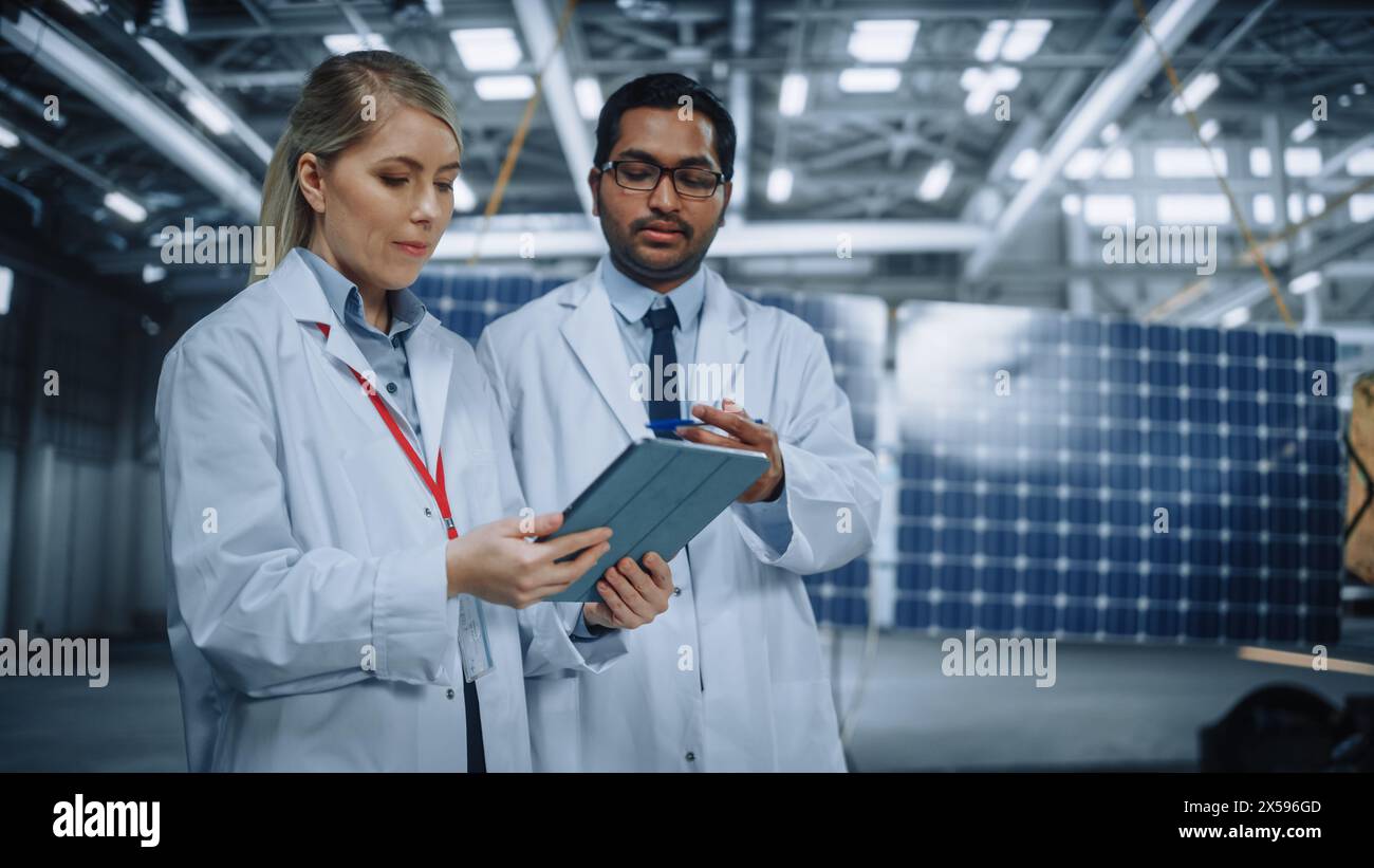 Two Engineers Talk, Use Tablet Computer while Working on Satellite ...
