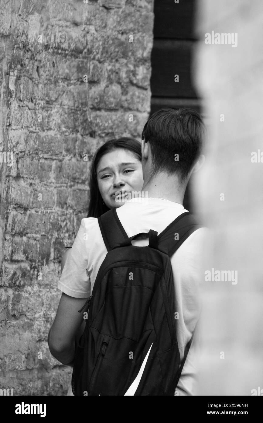 Urban landscape features crying woman comforted by supportive boyfriend ...