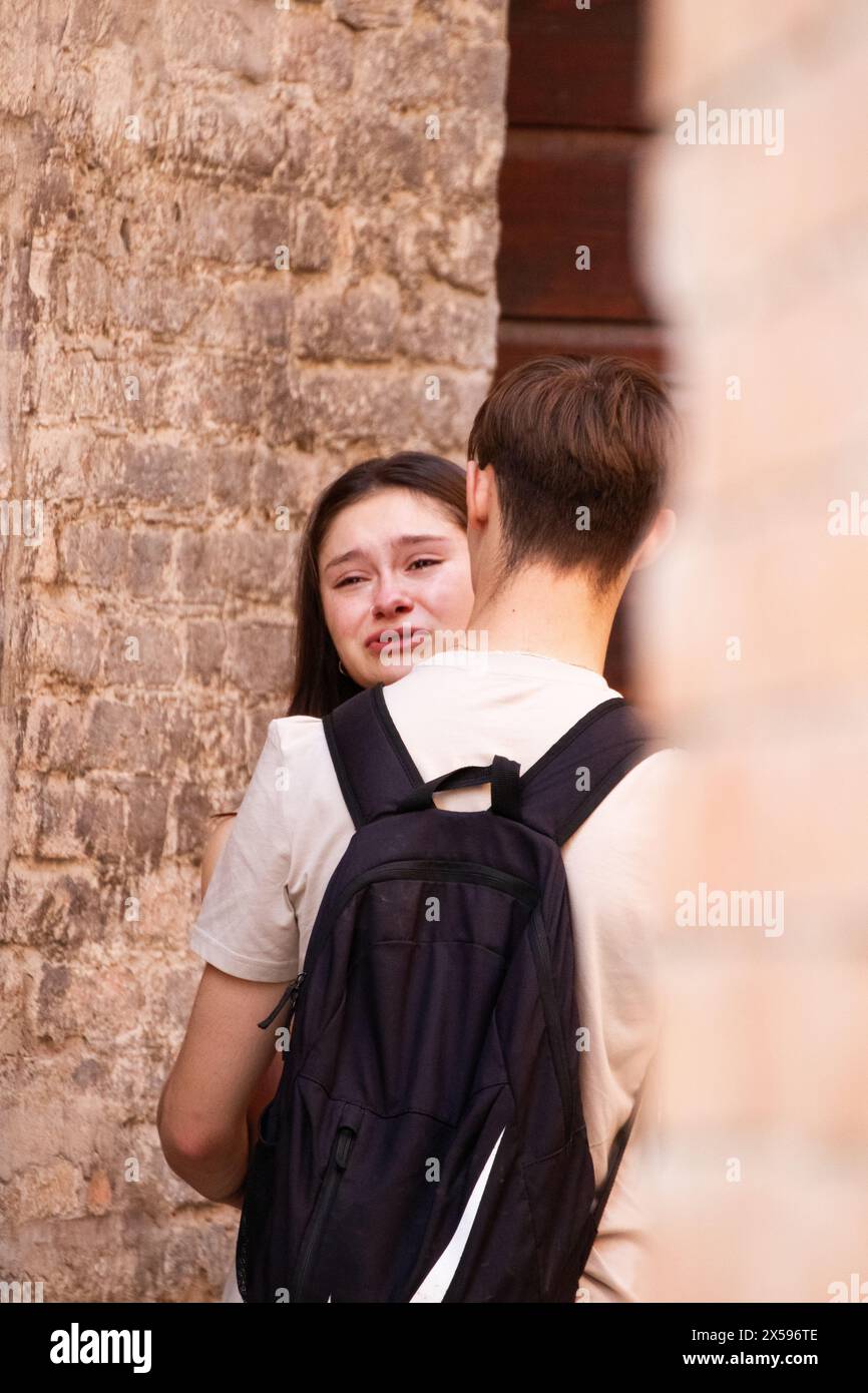 Urban landscape features crying woman comforted by supportive boyfriend ...
