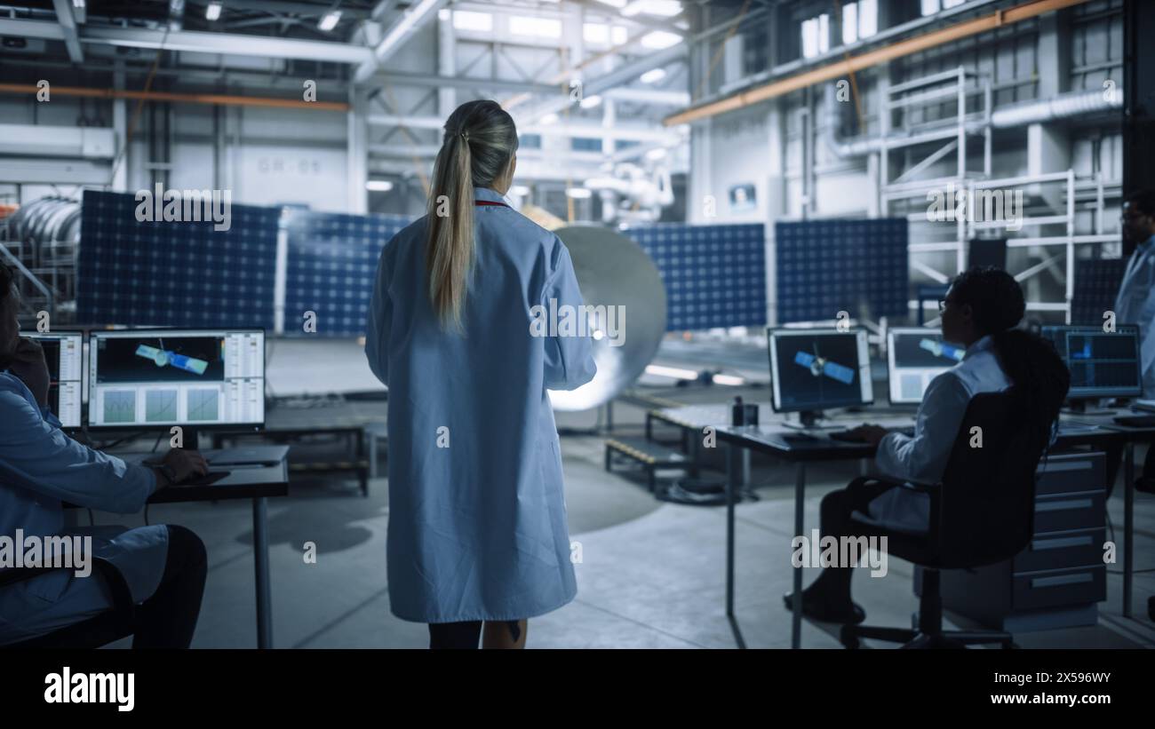 Female Engineer Uses Tablet Computer While Working On Satellite