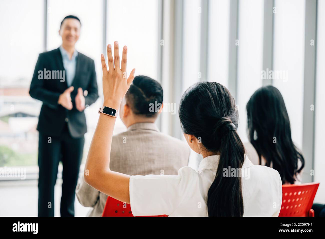 Audience engagement at a conference as hands are raised for questions ...