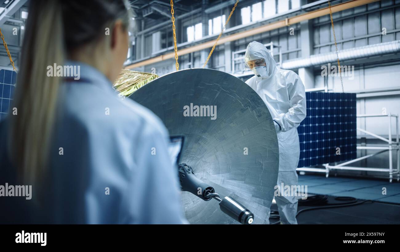 Female Engineer Uses Digital Tablet Computer while Working on Satellite ...