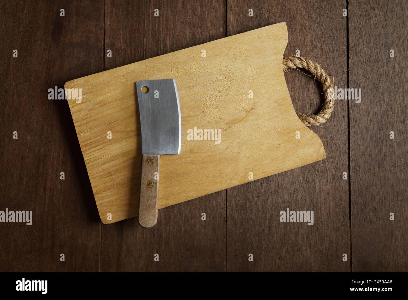 A mini meat cleaver knife on wooden cutting board with ropes Stock ...