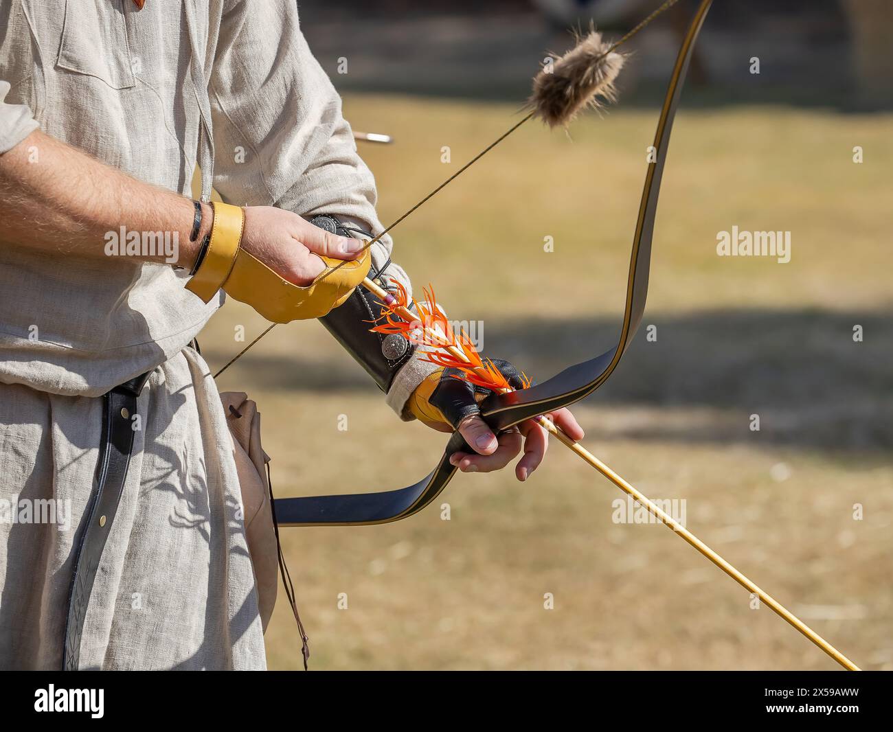 Medieval archery equipment, bow and arrow in the hands of a man ...