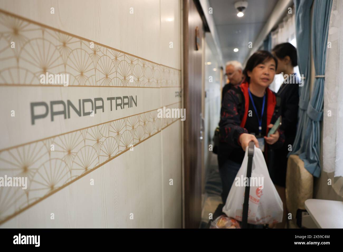 (240508) -- GUIYANG, May 8, 2024 (Xinhua) -- Passengers board a "Panda Train" at Guiyang railway ...