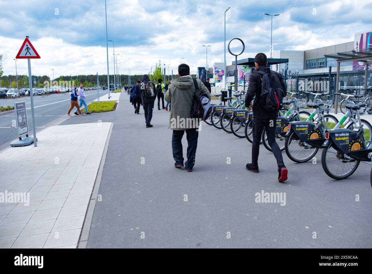 crowd workers men, people going to work shift at Tesla Gigafactory ...