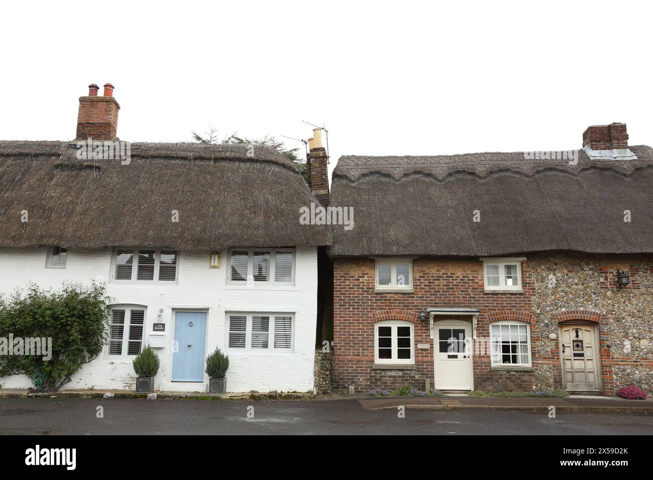 Two thatched houses side by side with chimney between them - concept ...