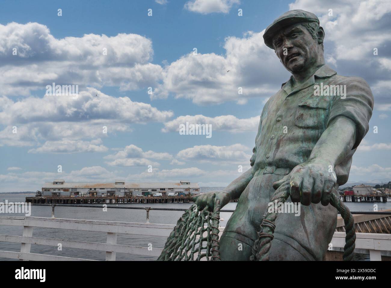 Bronze fisherman statue on coastal pier with ocean background Stock ...