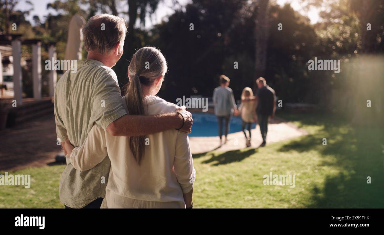 Senior couple, garden and hug from behind with family for good memories ...