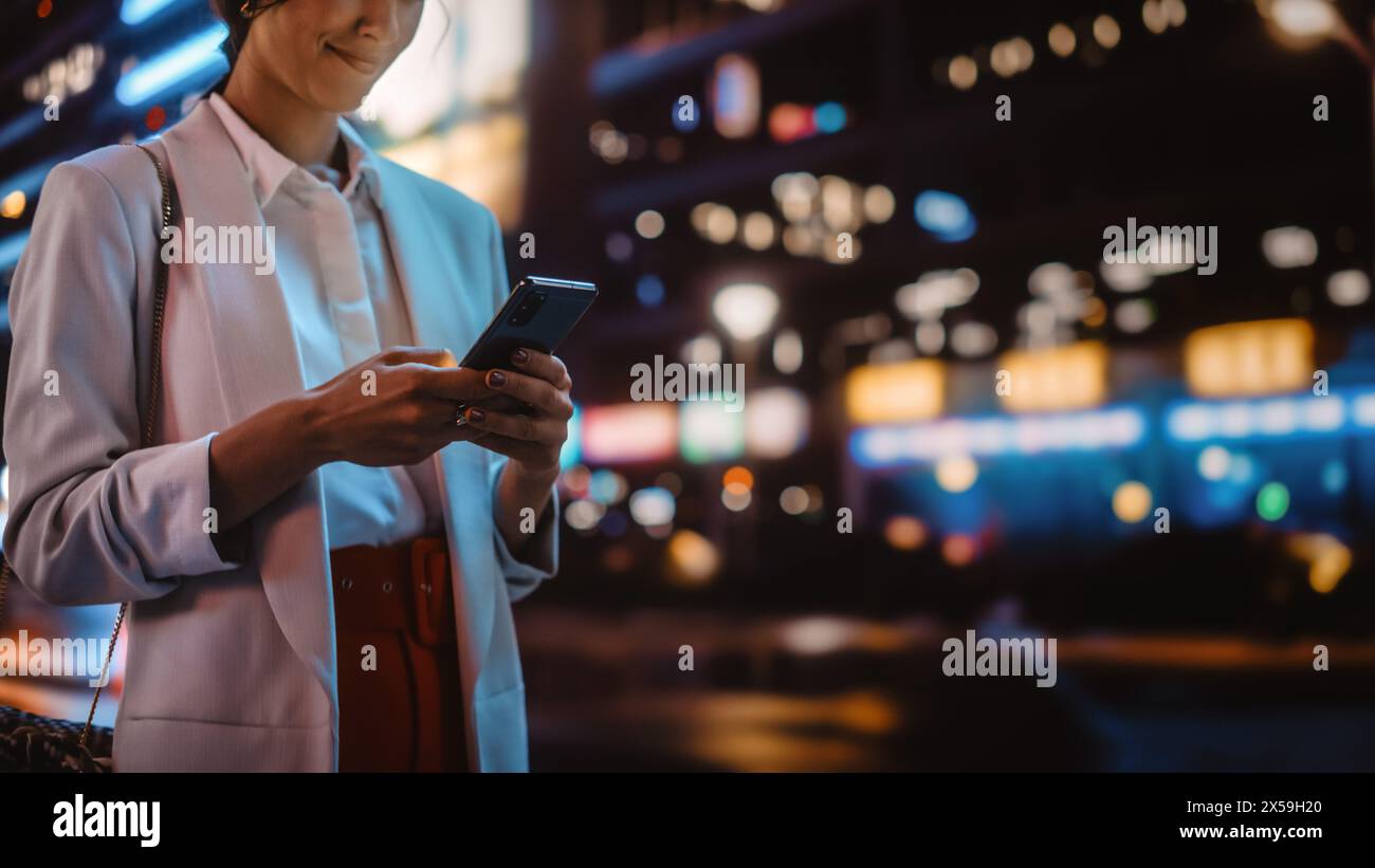 Anonymous Female Using Smartphone Walking Through Night City Street ...