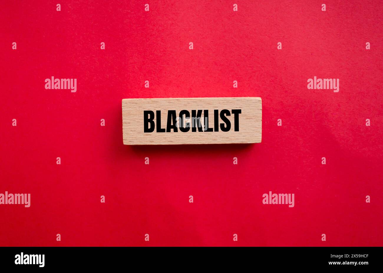 Blacklist word written on wooden block with red background. Conceptual ...