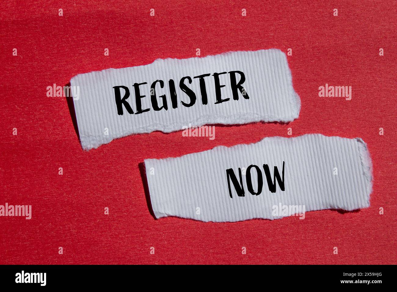 Register now words written on ripped white paper pieces with red ...
