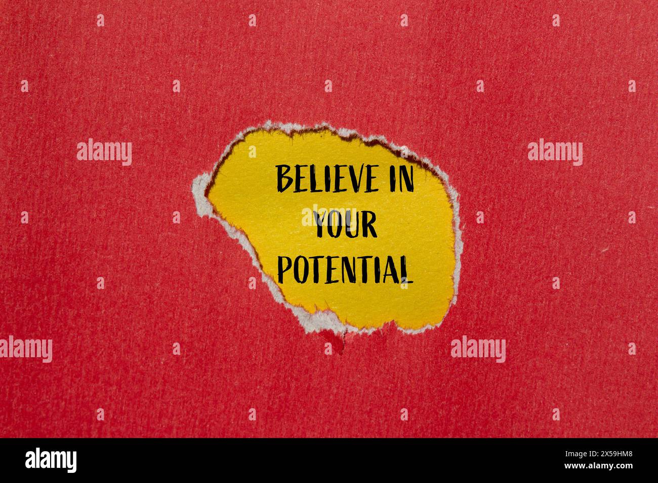 Believe in your potential words written on ripped red paper with yellow ...