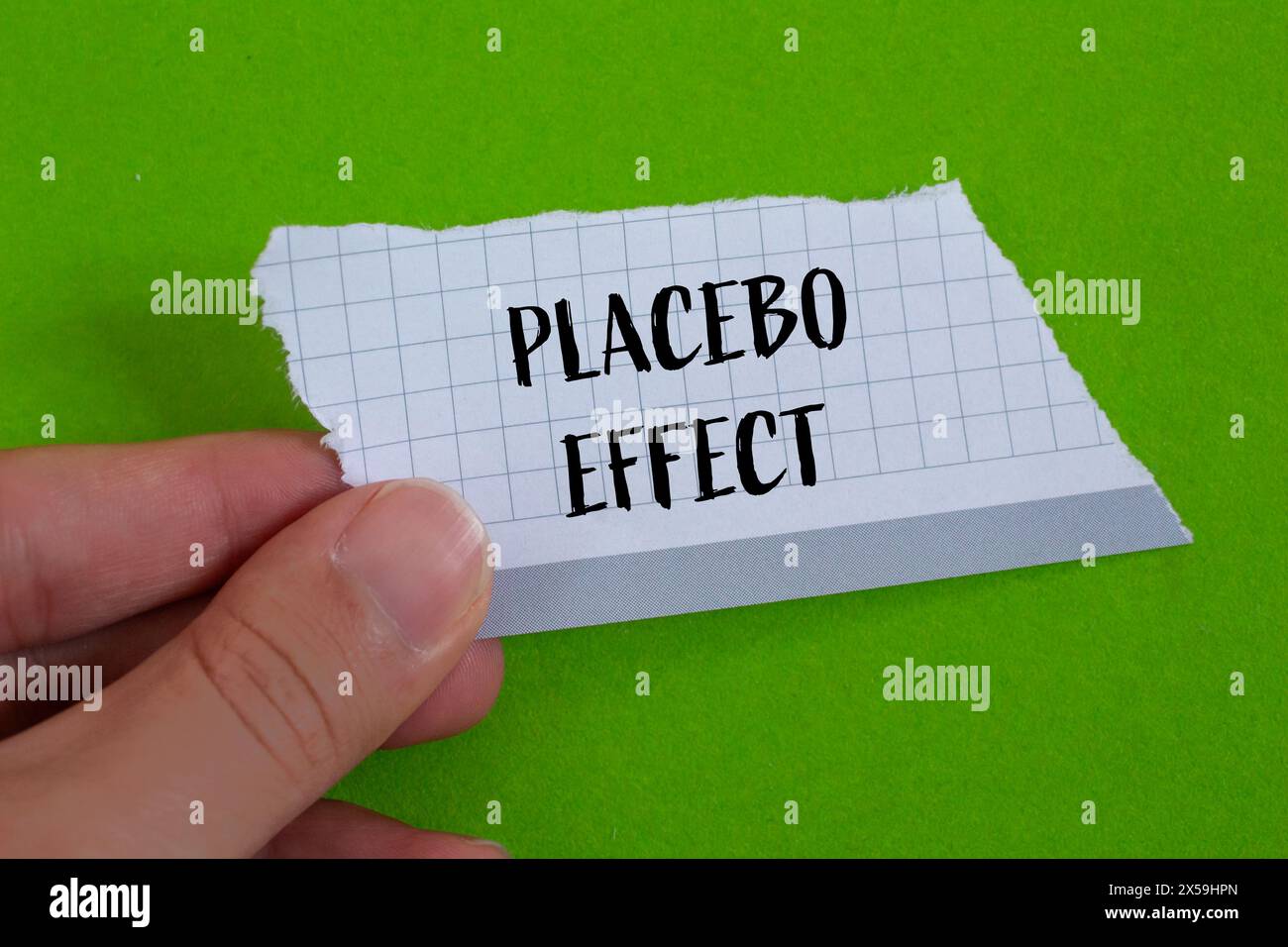 Placebo effect words written on ripped paper with green background ...