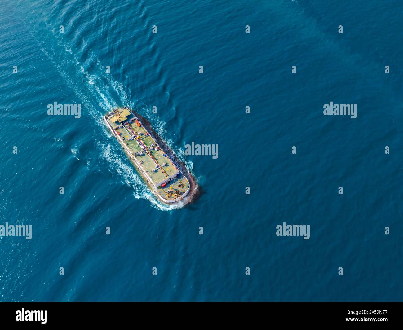 Aerial front side view of small mini oil tanker ship sailing on open ...