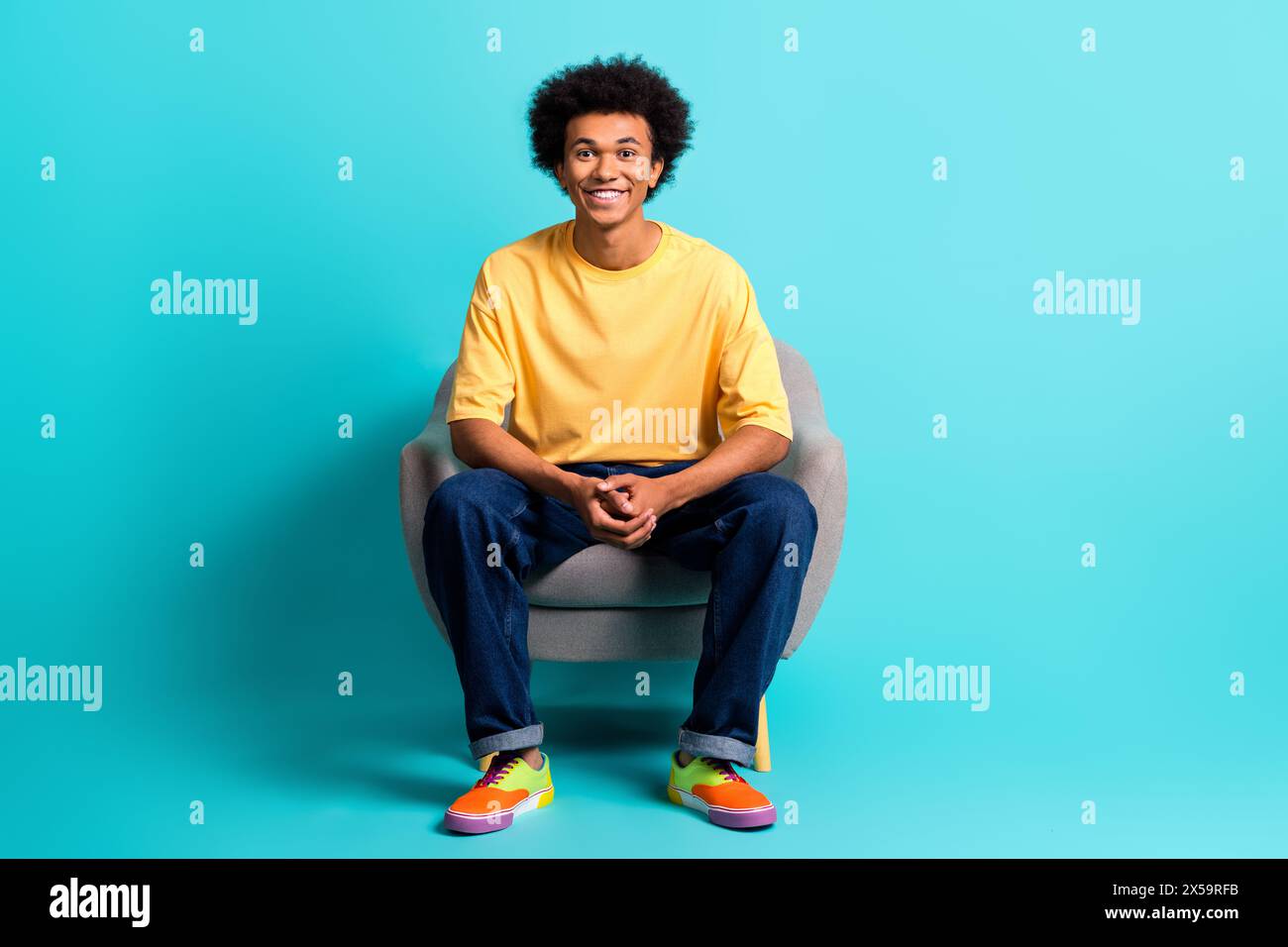 Full length photo of satisfied guy dressed yellow t-shirt jeans sit on ...
