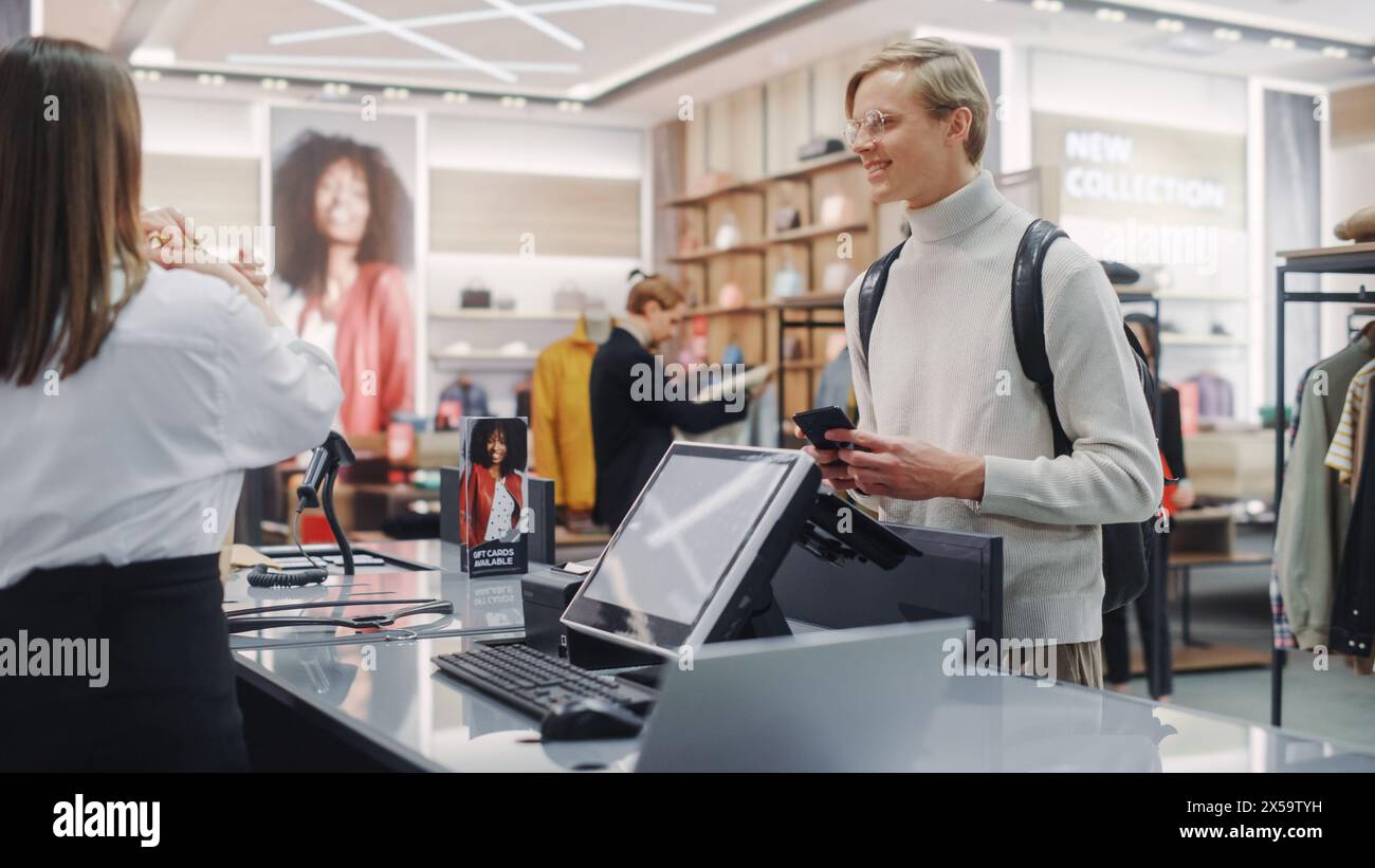 Clothing Store: Young Man At Checkout Counter Buys Clothes Paying with ...