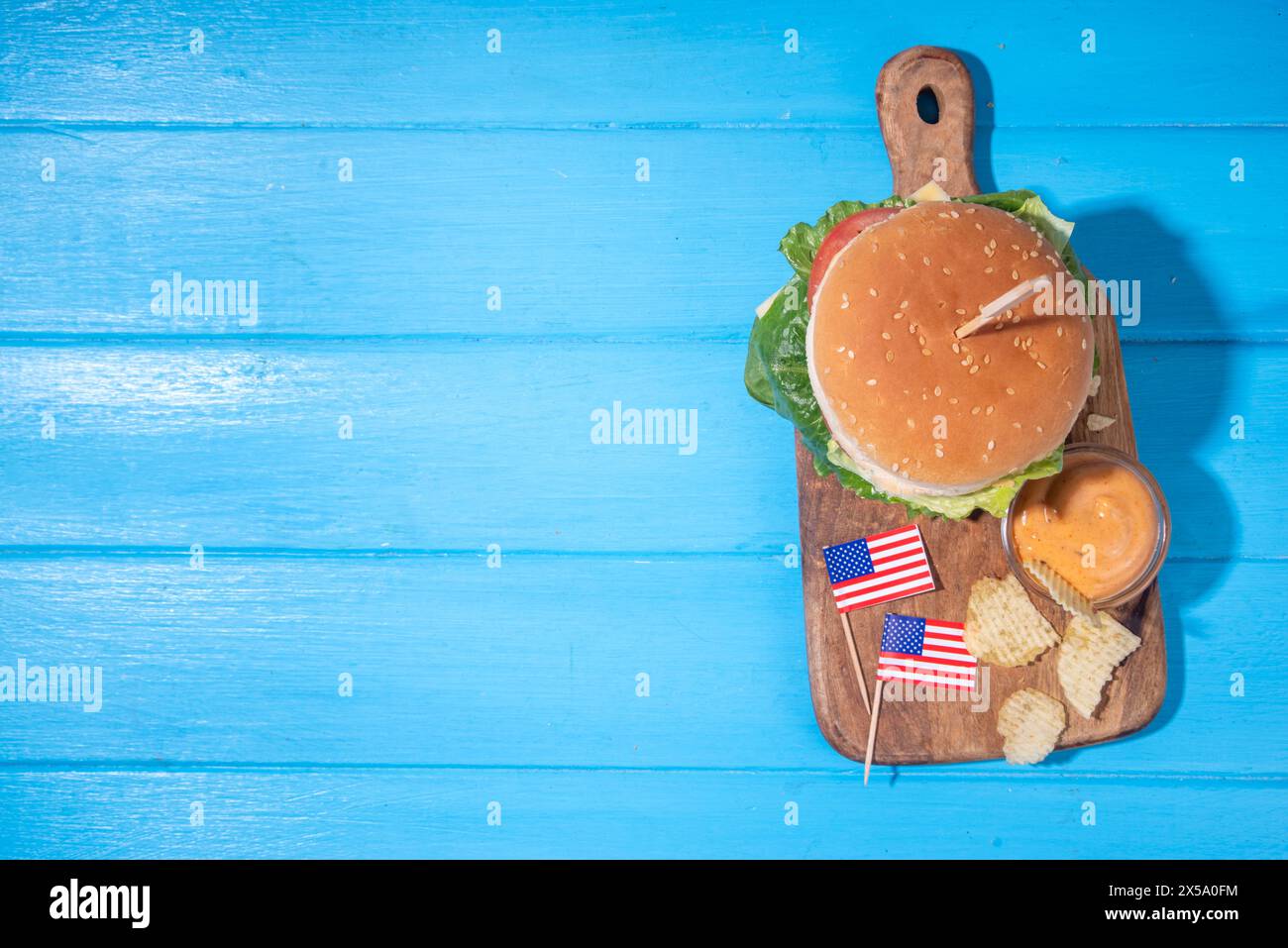Tasty cheeseburger, chips and sauce with patriotic american flag. July ...