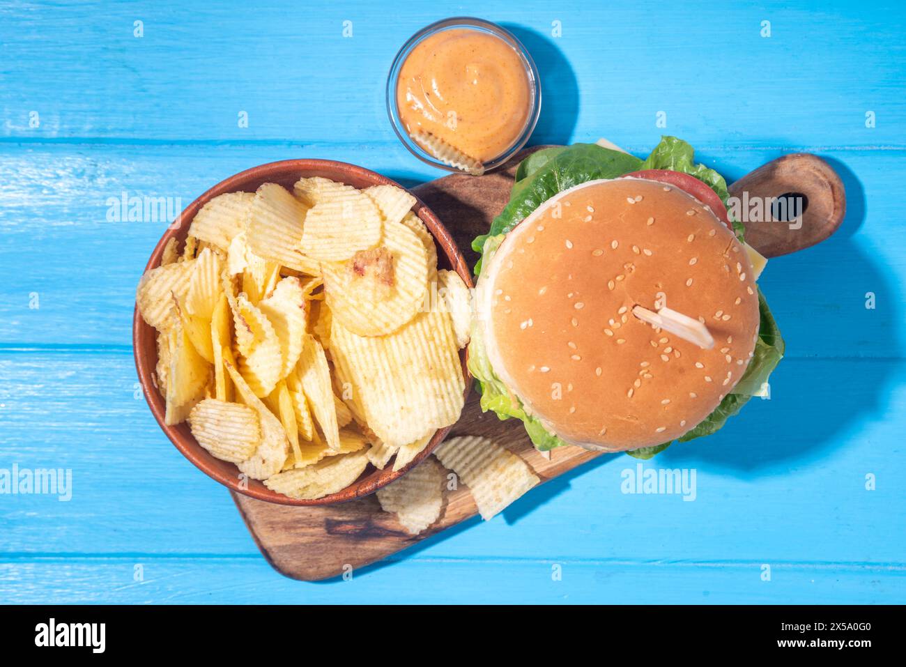 Tasty cheeseburger, chips and sauce with patriotic american flag. July ...