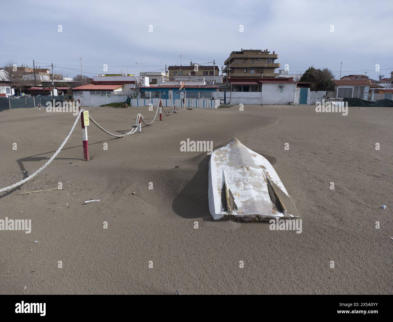 Wreck of a small fibreglass boat on a Latium beach in central Italy, in ...