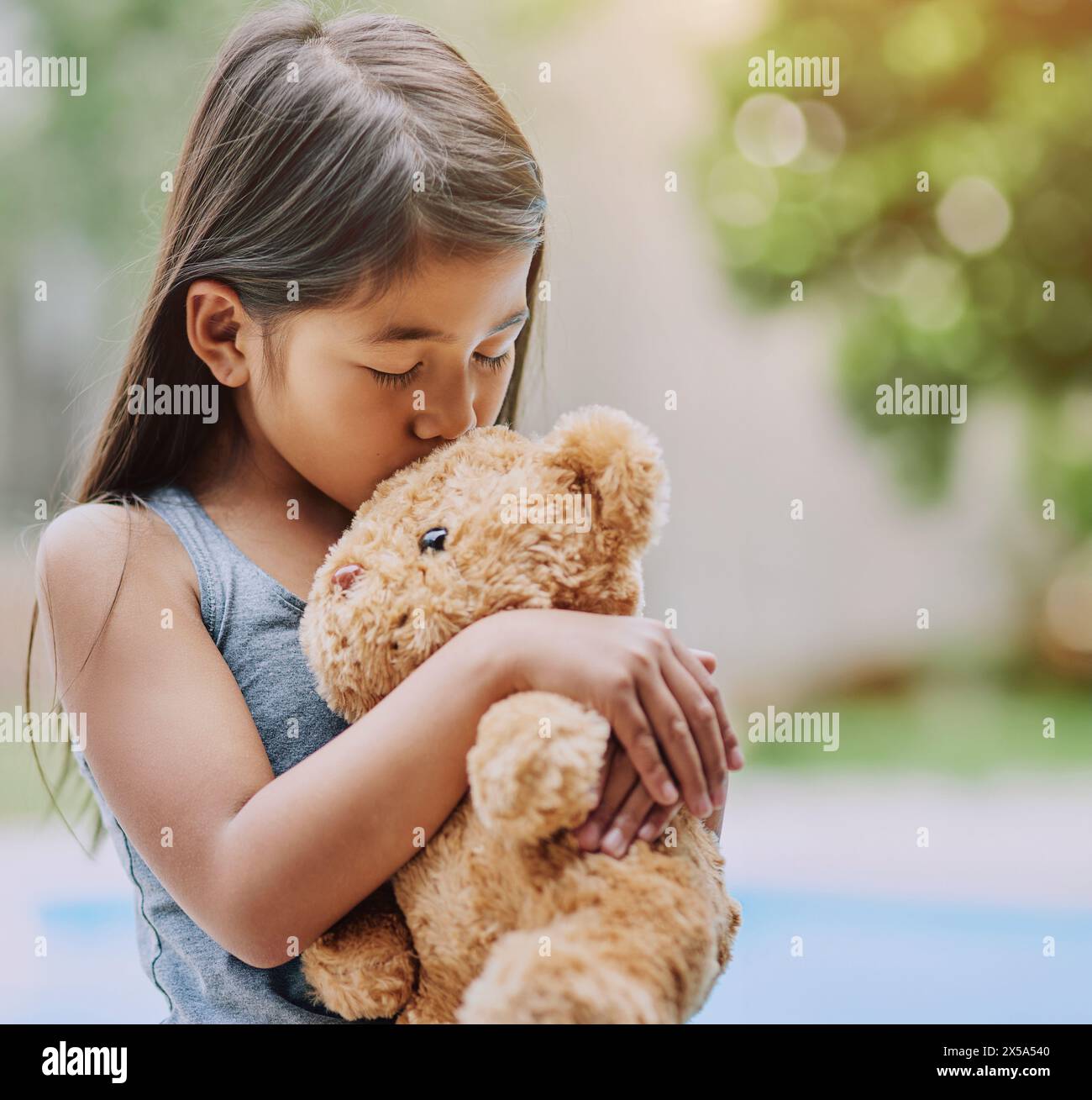 Happy, outdoor and girl with teddy bear, kissing and comfortable with ...