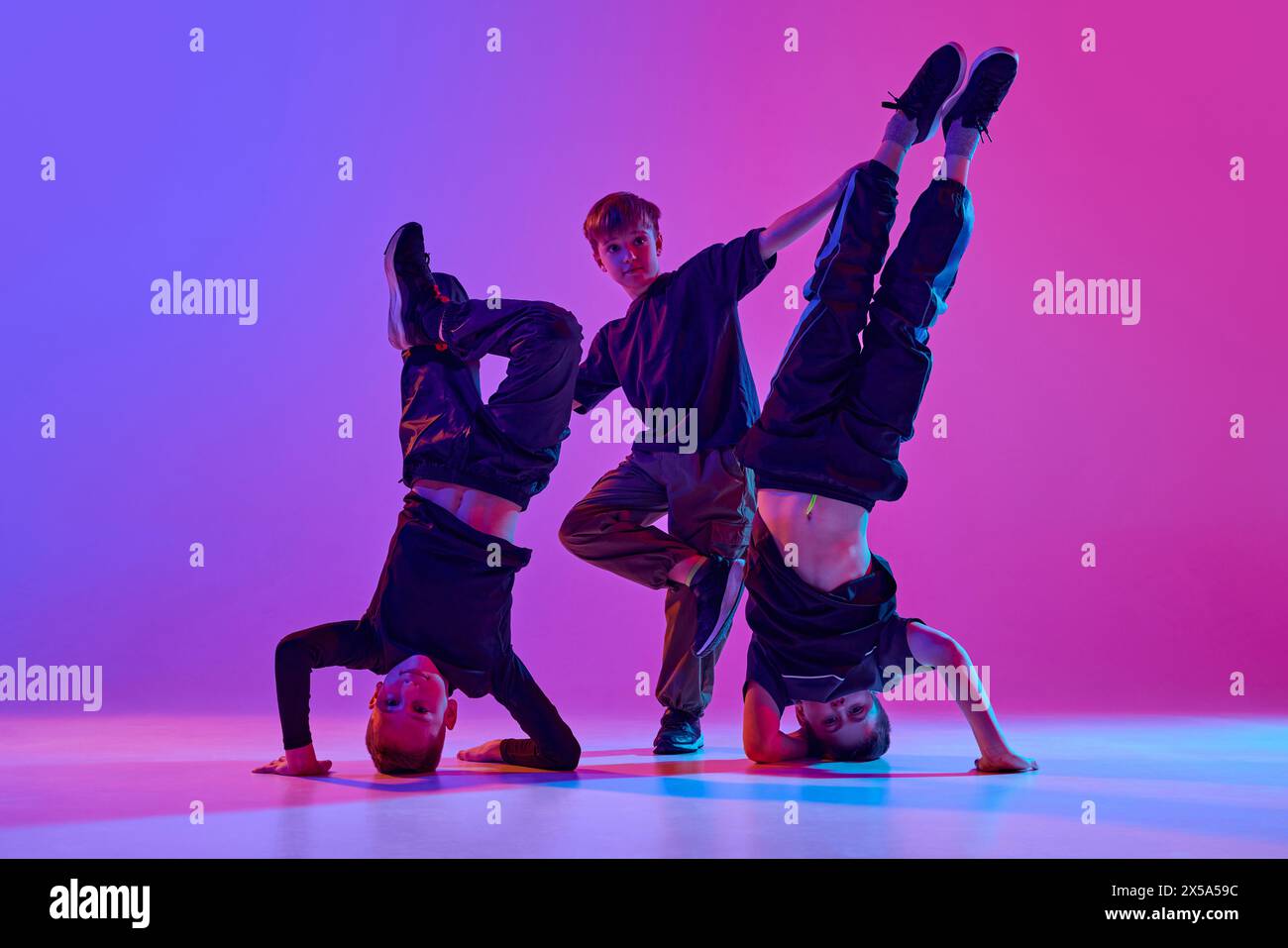 Energetic photo of young boys, in black attire dancing breakdance in ...