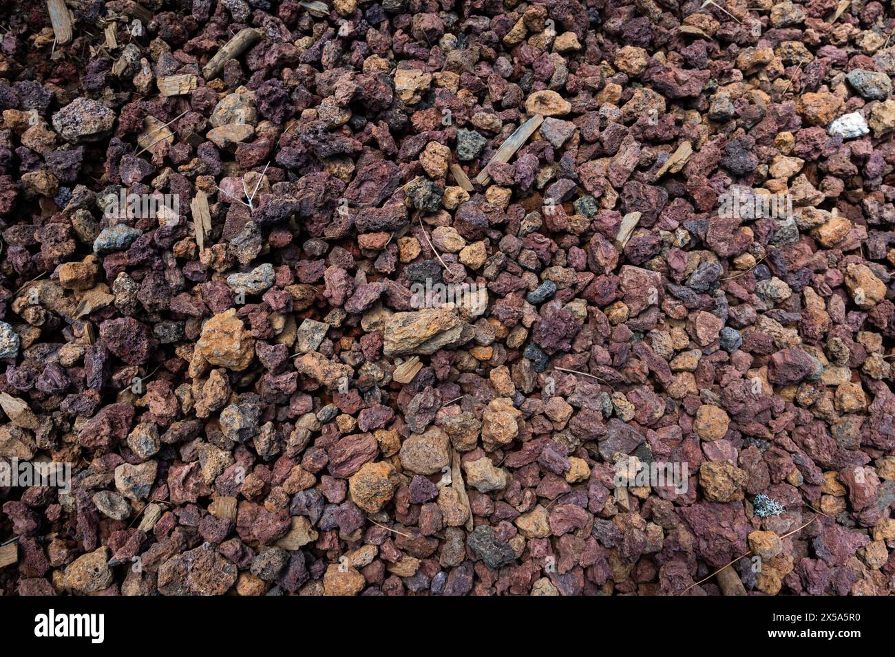 A pile of red and brown rocks. The rocks are scattered and unevenly ...