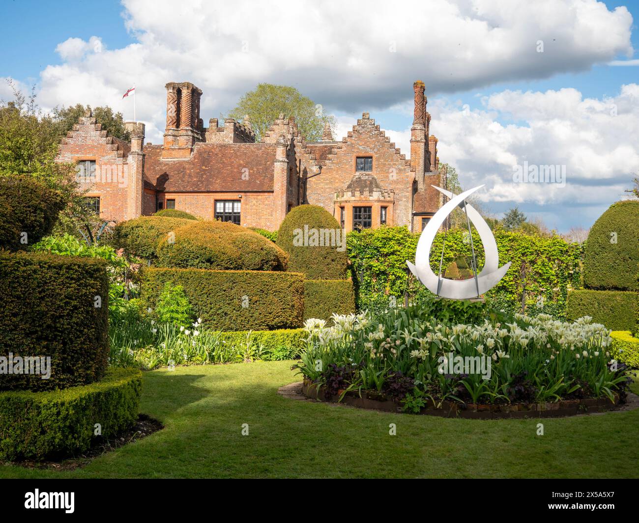 Chenies Manor House seen from the Topiary garden with sculpture feature ...