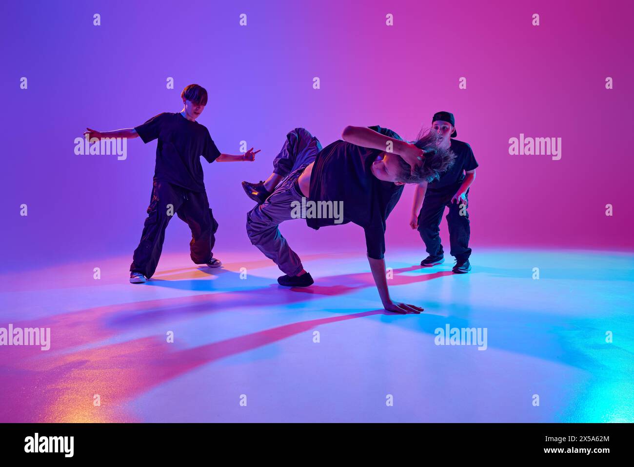 Three young male dancers participate in street dance battle in mixed ...