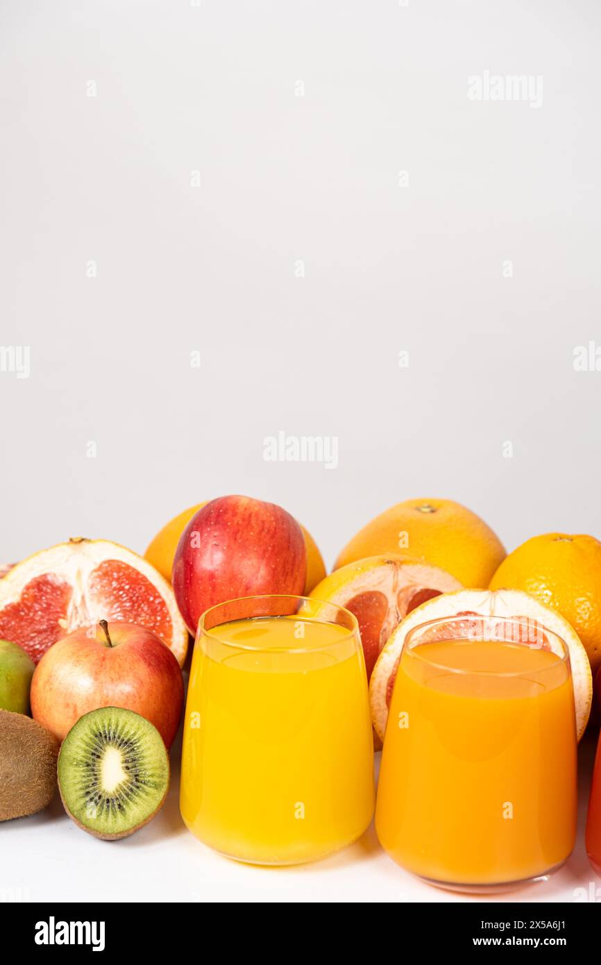 Orange and multifruit juices in glasses on white background with space ...