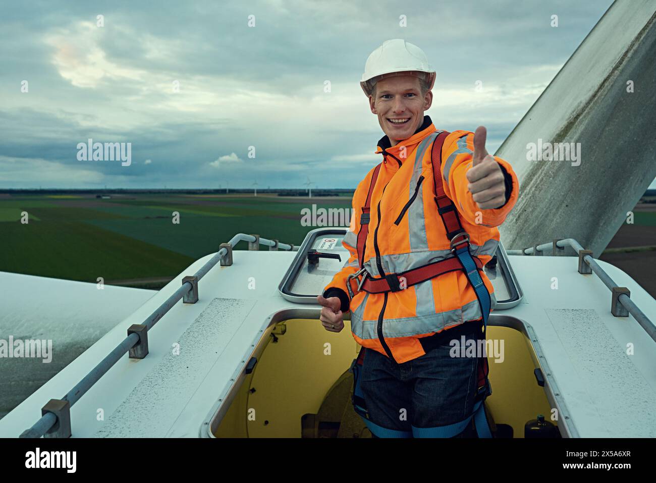 Wind turbine, thumbs up and portrait of man in electricity maintenance ...