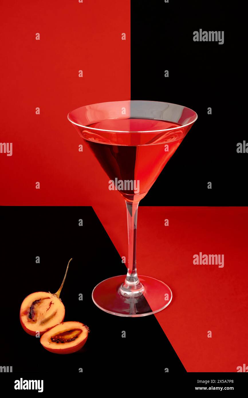 A vibrant red cocktail in a martini glass, contrasted with a split ...