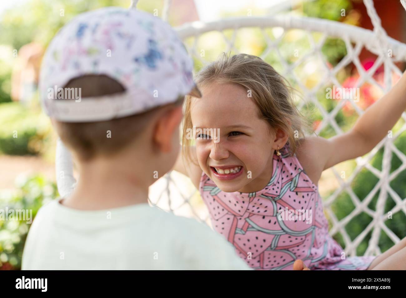 Two young siblings are having a delightful time outdoors in the ...