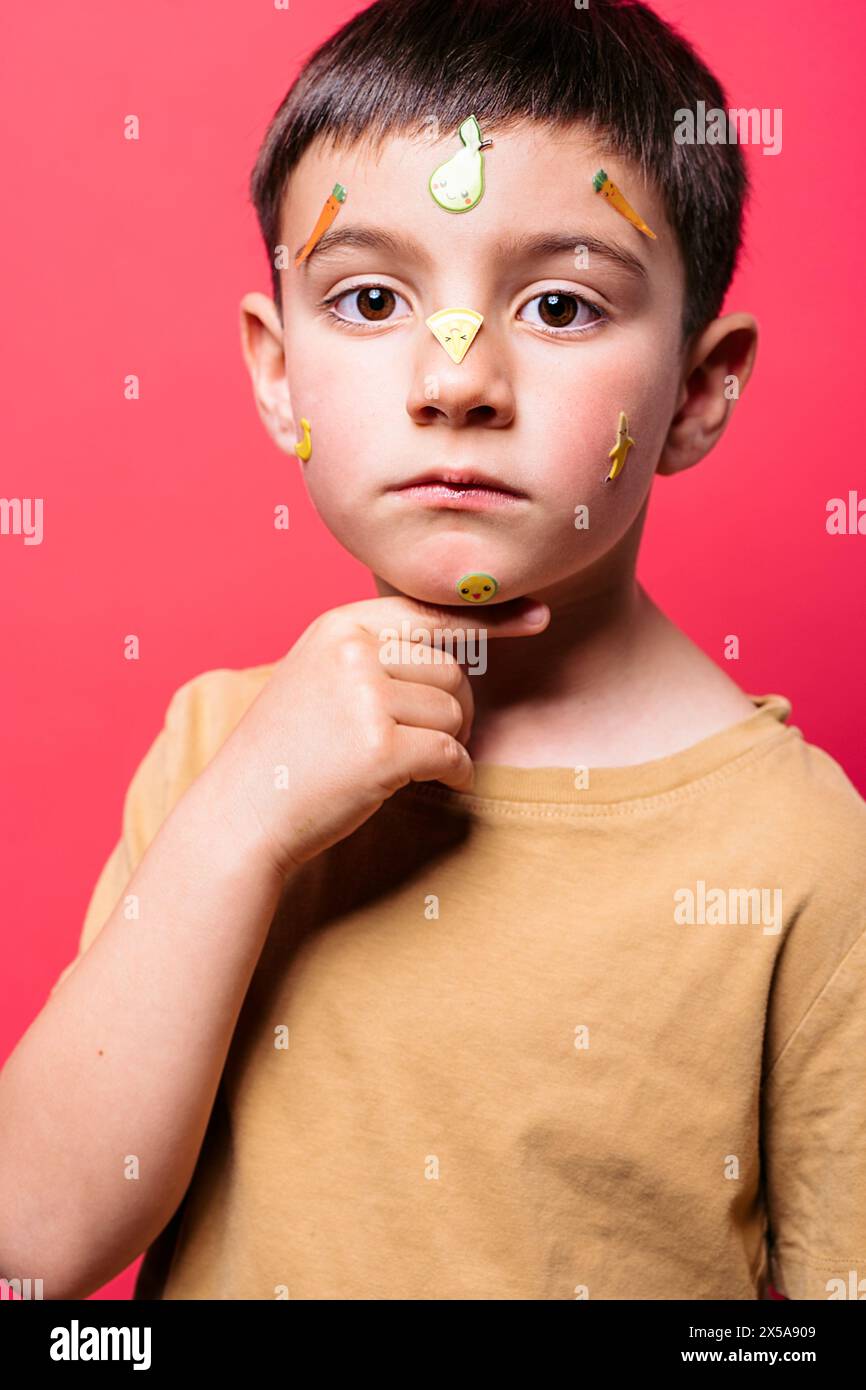 A young boy with a contemplative expression, adorned with colorful ...