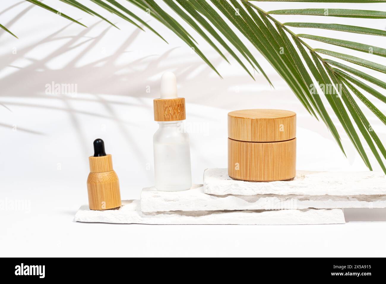 Elegant cosmetic containers with bamboo lids are presented against a ...