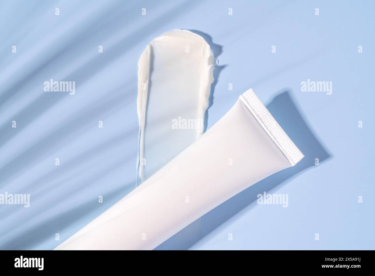 A soothing image showcasing a white cream dollop with its tube ...