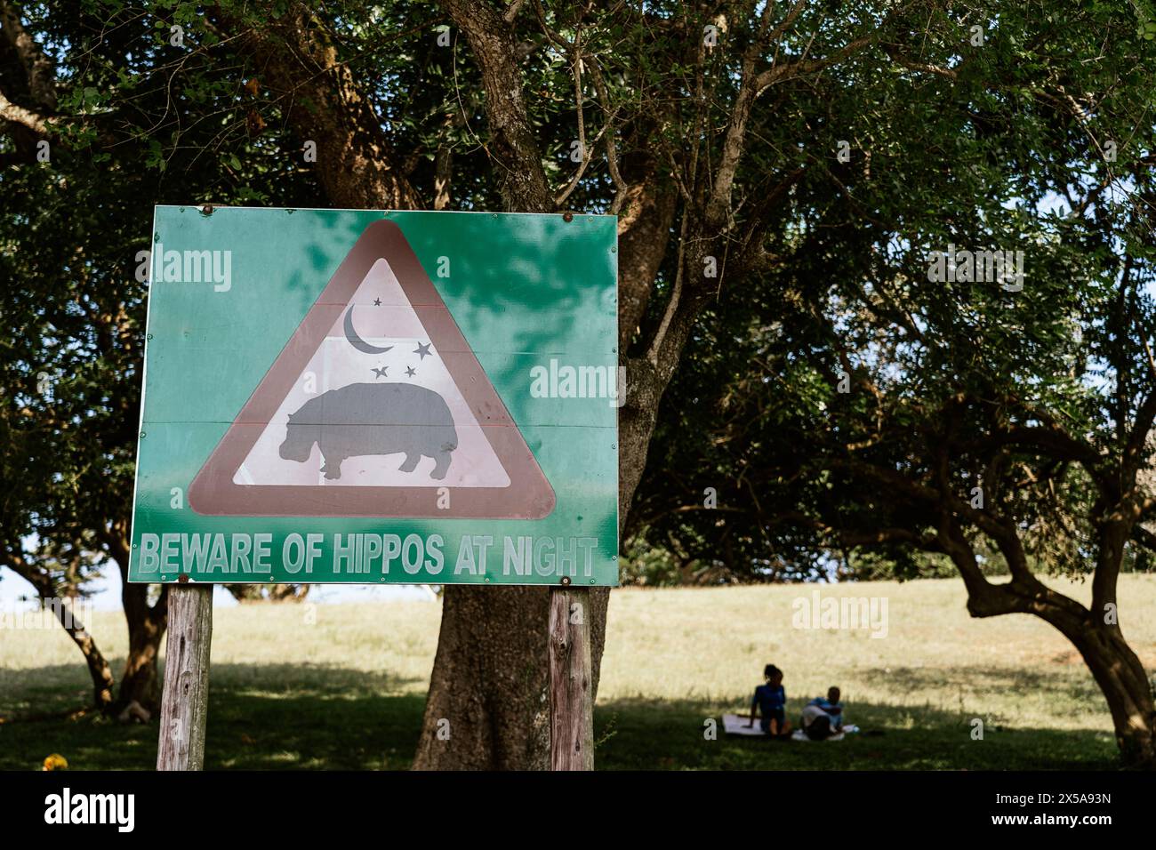 A weathered green caution sign with a hippo silhouette warns of ...