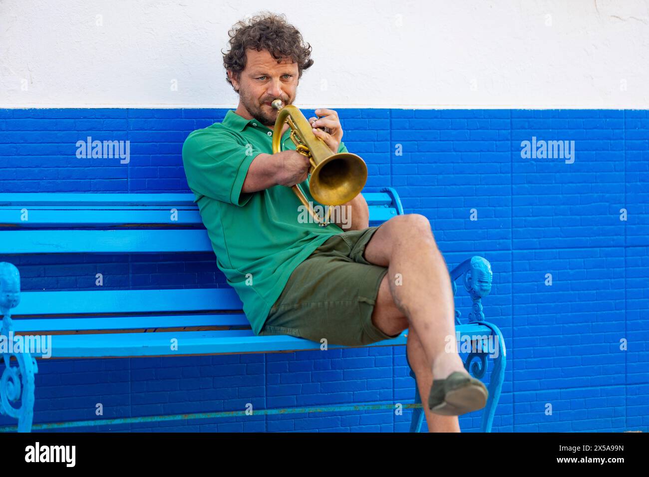 An inspiring one-armed man playing the trumpet while seated on a ...