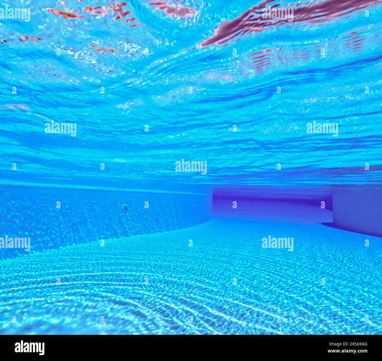 A tranquil underwater scene in a crystal-clear, blue swimming pool ...