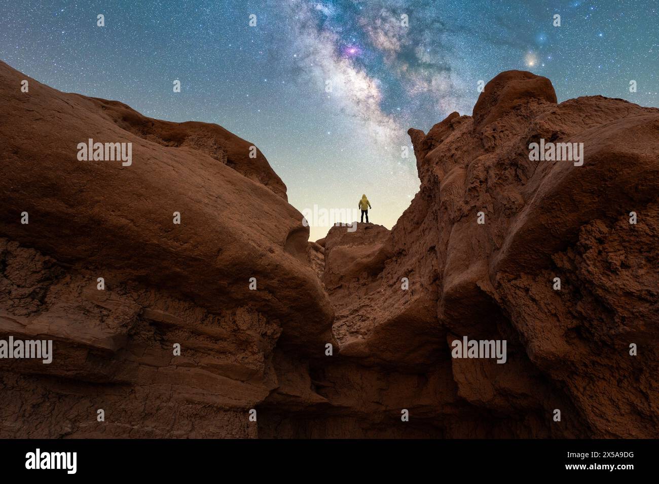 An adventurer stands atop a formation in Goblin Valley State Park, Utah ...