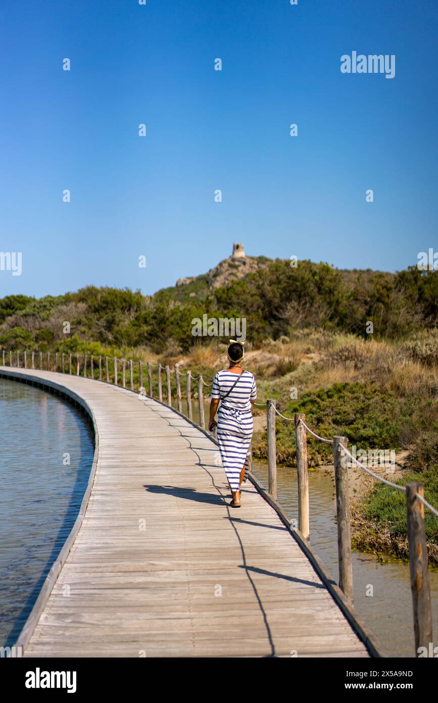 An individual takes a peaceful stroll down a curved wooden boardwalk ...