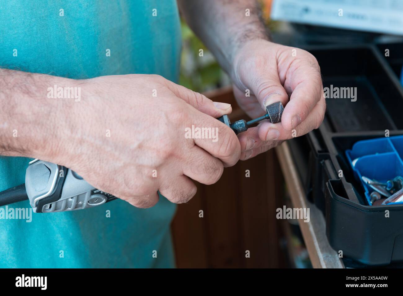 Close-up of a man's hands selecting tools for sanding and varnishing ...
