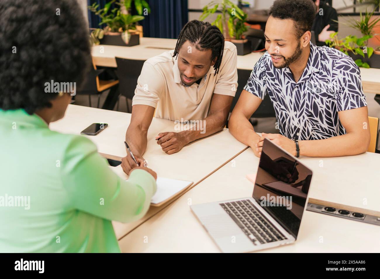 Three professionals are having a friendly and collaborative discussion ...